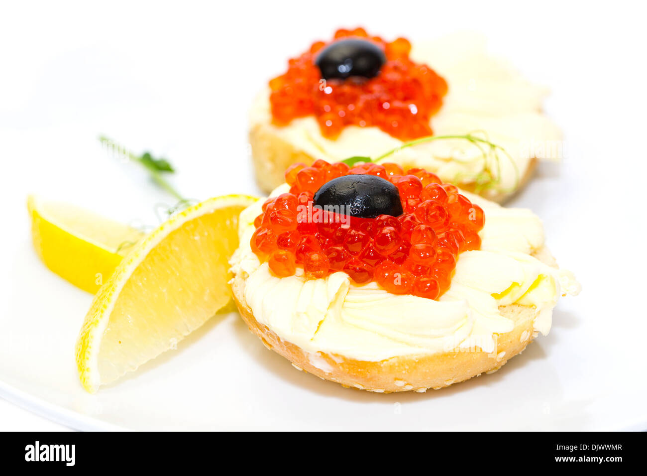 canape with red caviar and lemon on white background Stock Photo - Alamy