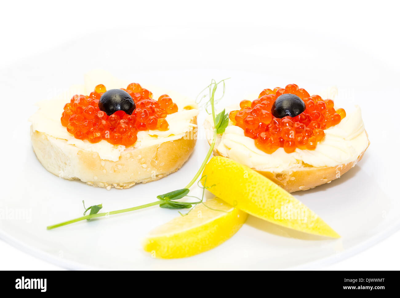 canape with red caviar and lemon on white background Stock Photo - Alamy
