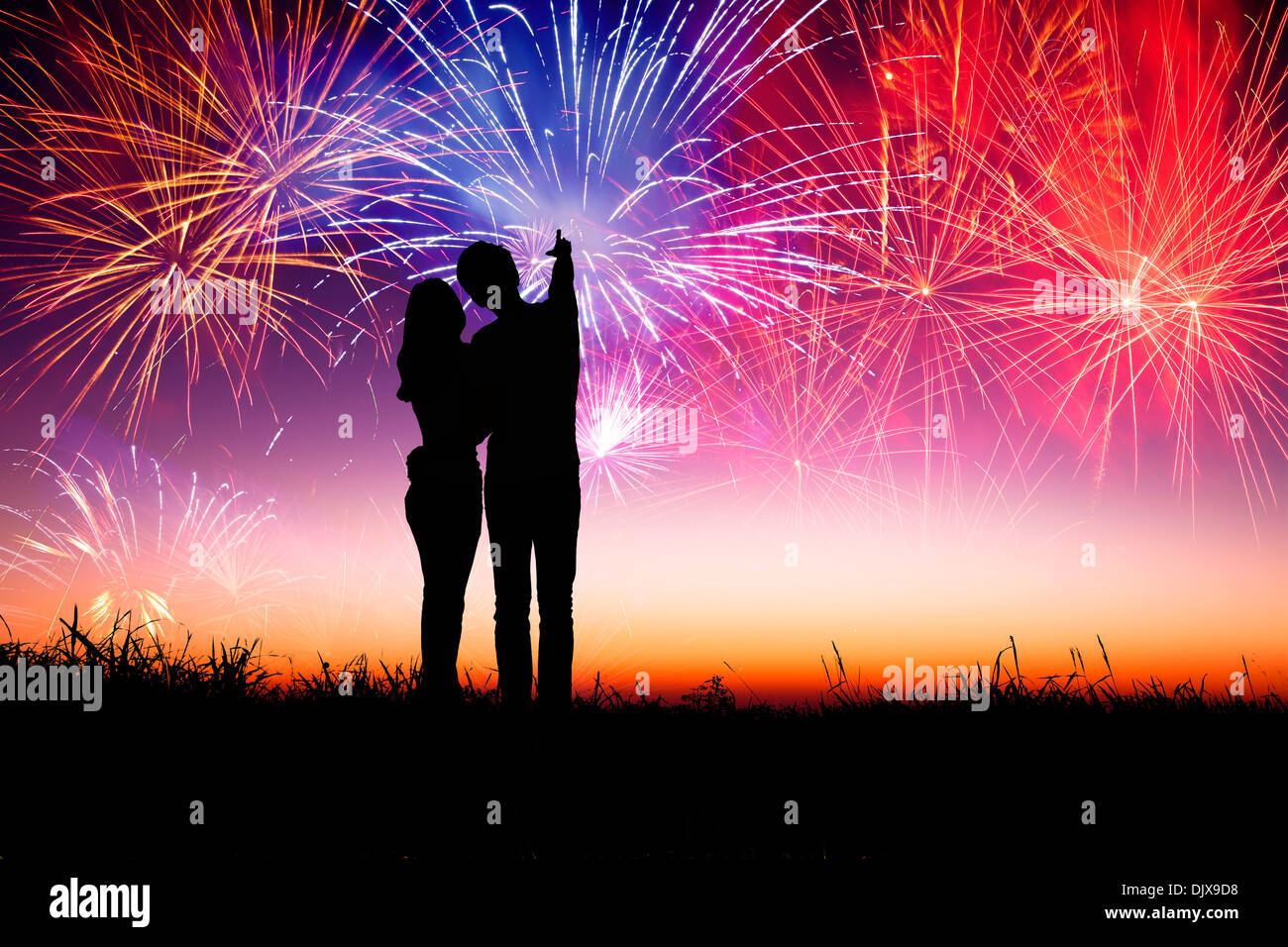 young couple standing on the hill and watching the fireworks Stock ...