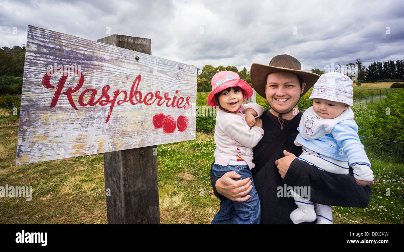Father Holding Children next to Raspberry sign Stock Photo - Alamy