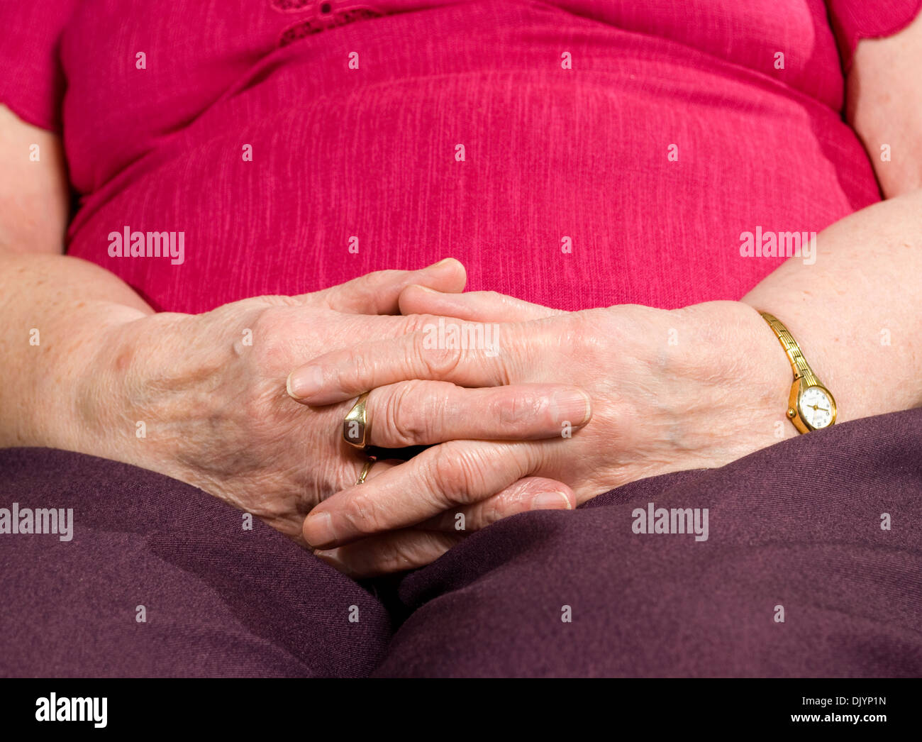 Hands clasped resting on lap hi-res stock photography and images - Alamy