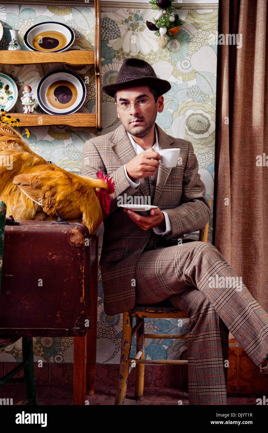 Retro guy drinking coffee with his bird Stock Photo - Alamy