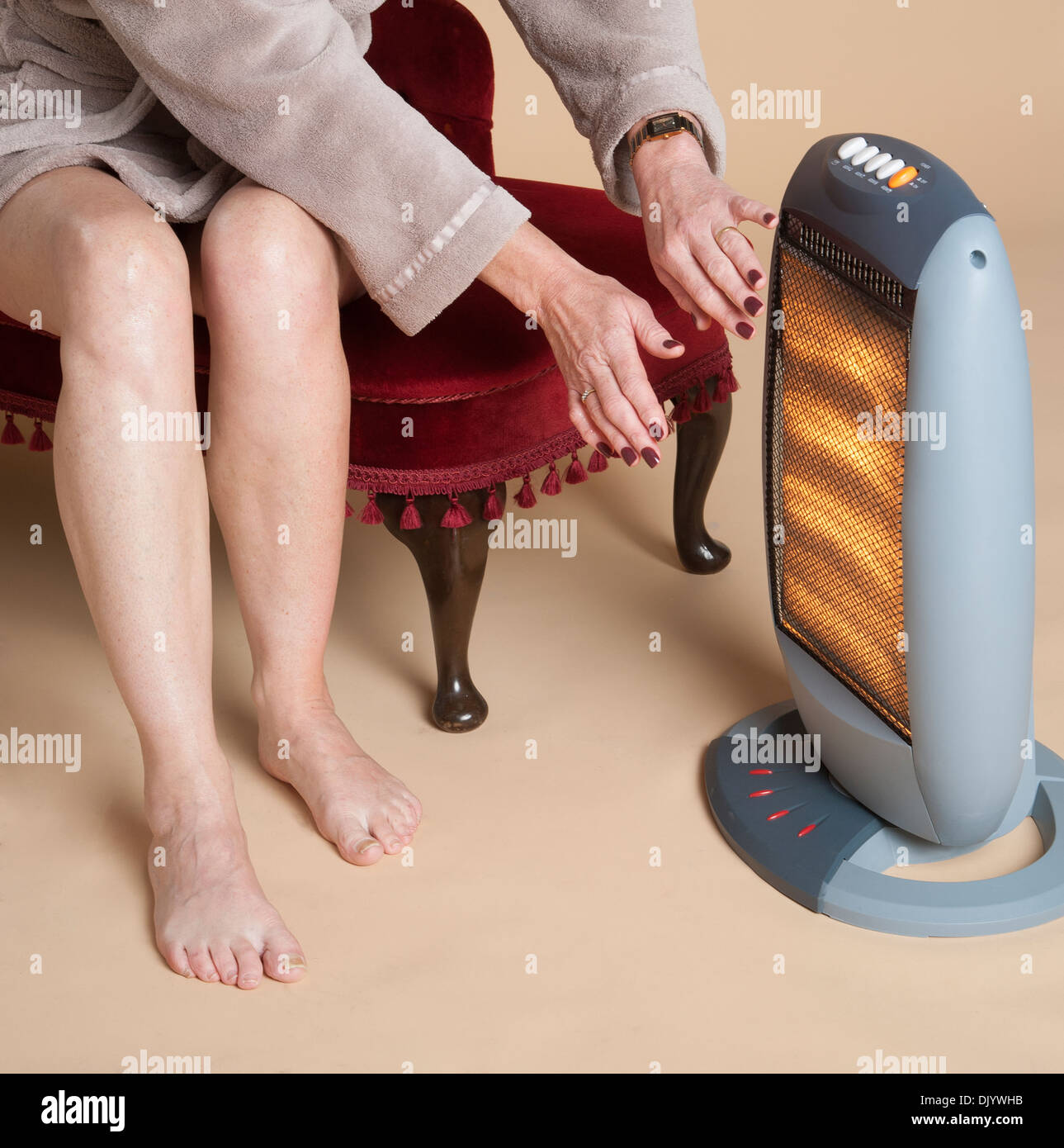 Woman keeping warm by an electric fire Stock Photo - Alamy