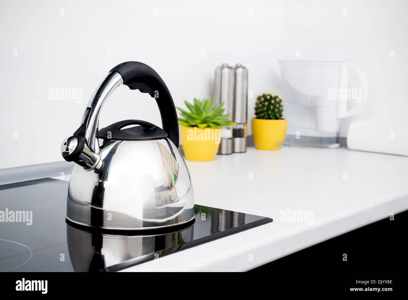 Steel kettle in modern kitchen with induction stove Stock Photo - Alamy