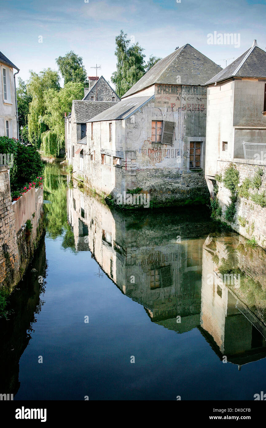 View of the tranquil L'Aure river flowing through the picturesque old ...