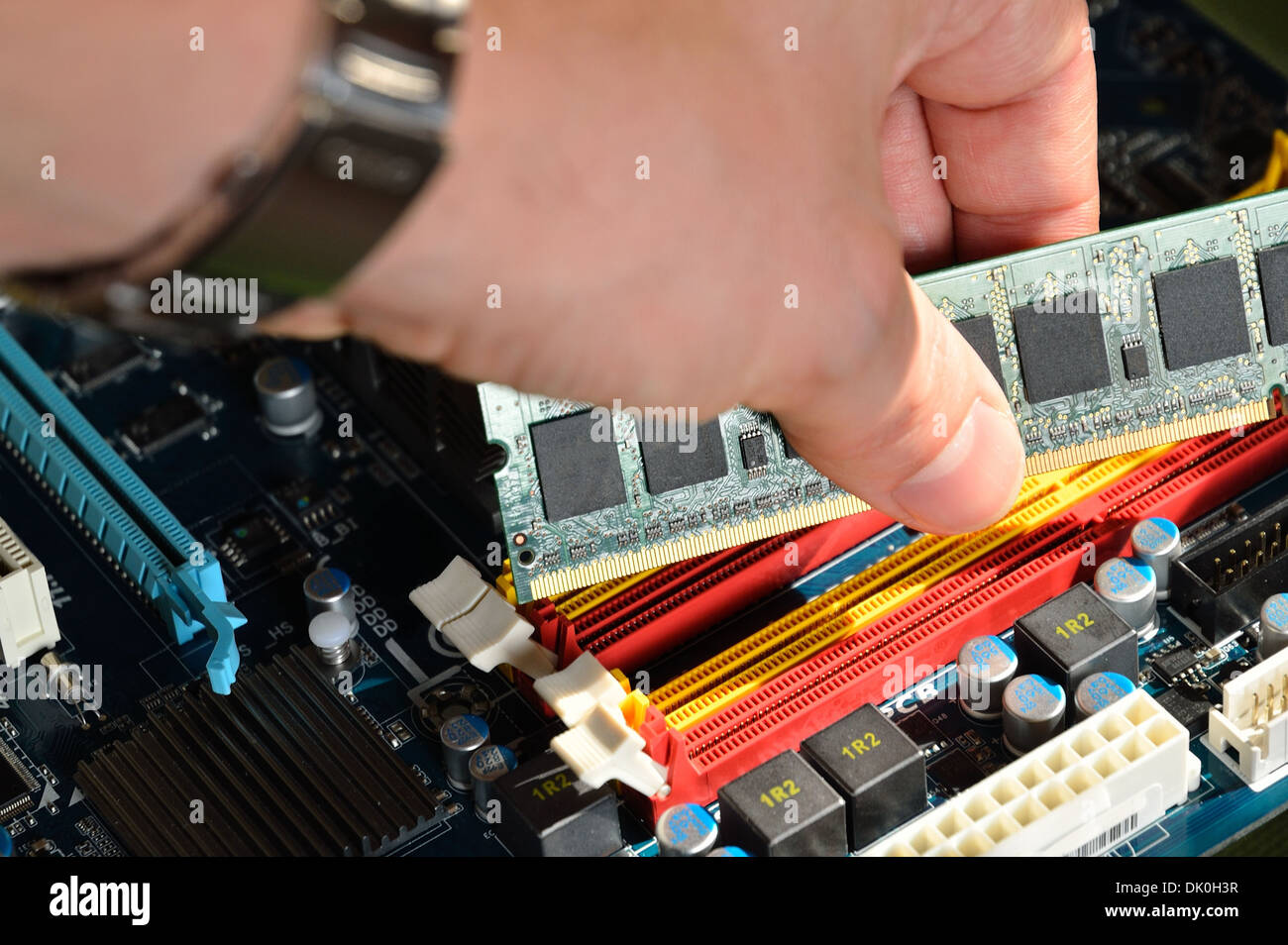 Installing green and black RAM computer memory Stock Photo - Alamy