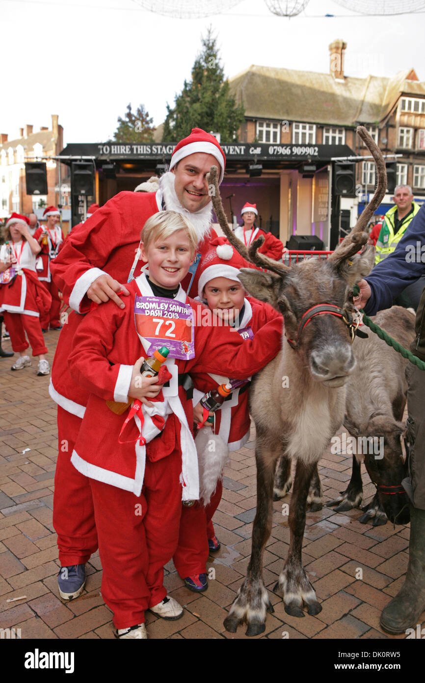 Bromley, UK. 1st Dec 2013. Santa Dash runners pose with reindeer ...