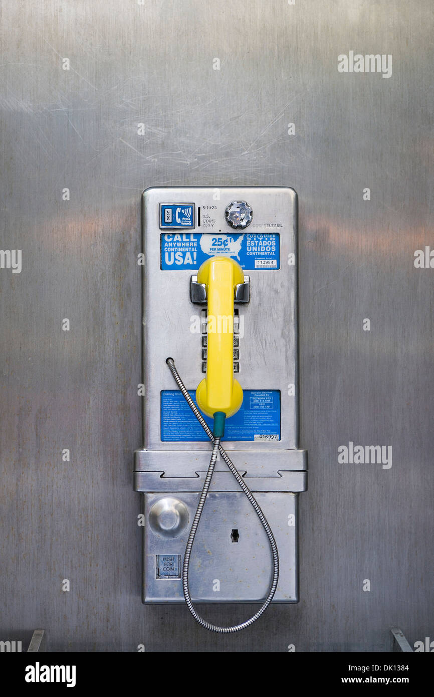 Coin operated public telephone in New York with a yellow receiver Stock ...