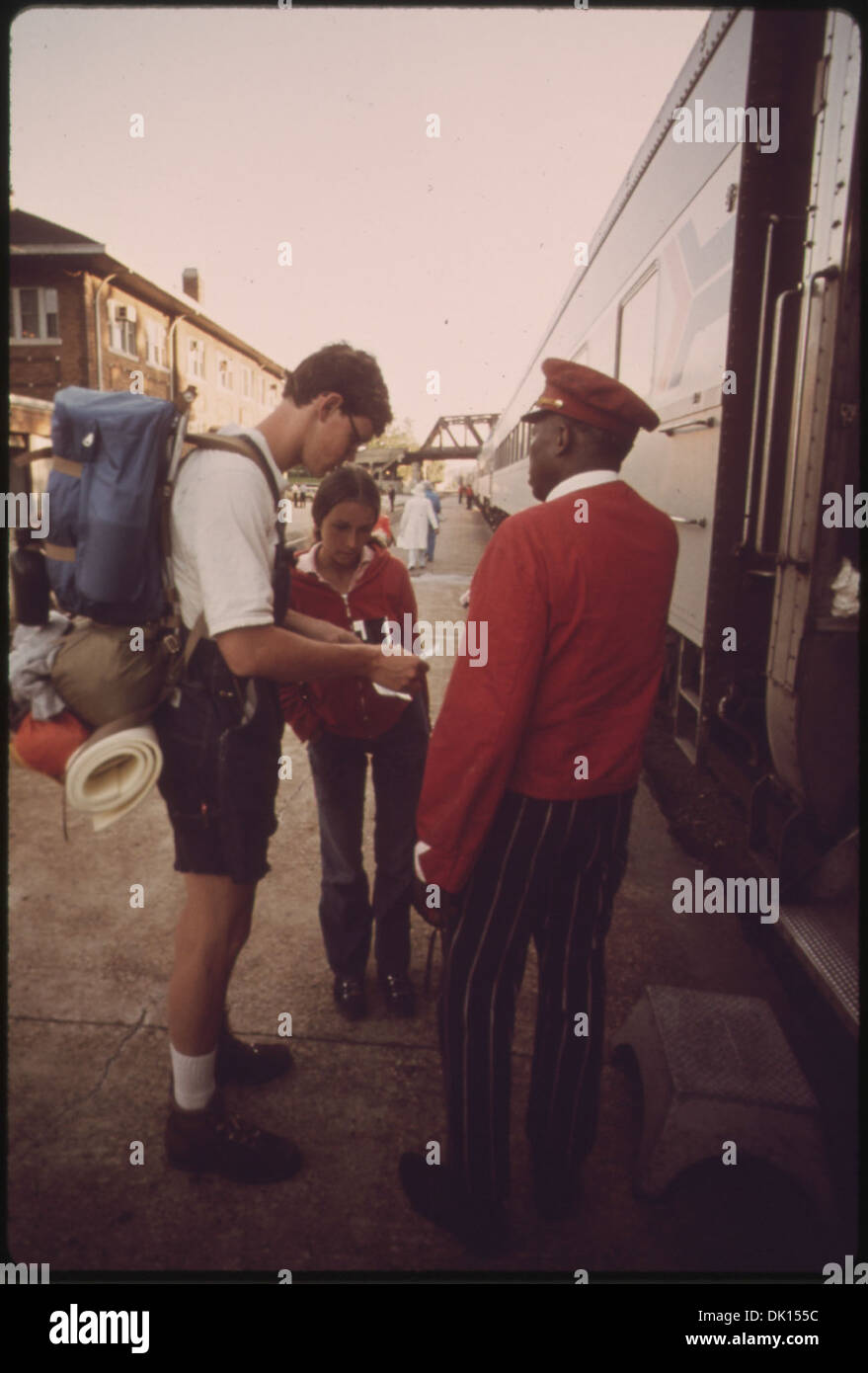 A passenger car attendant is assisting passengers aboard the Empire ...