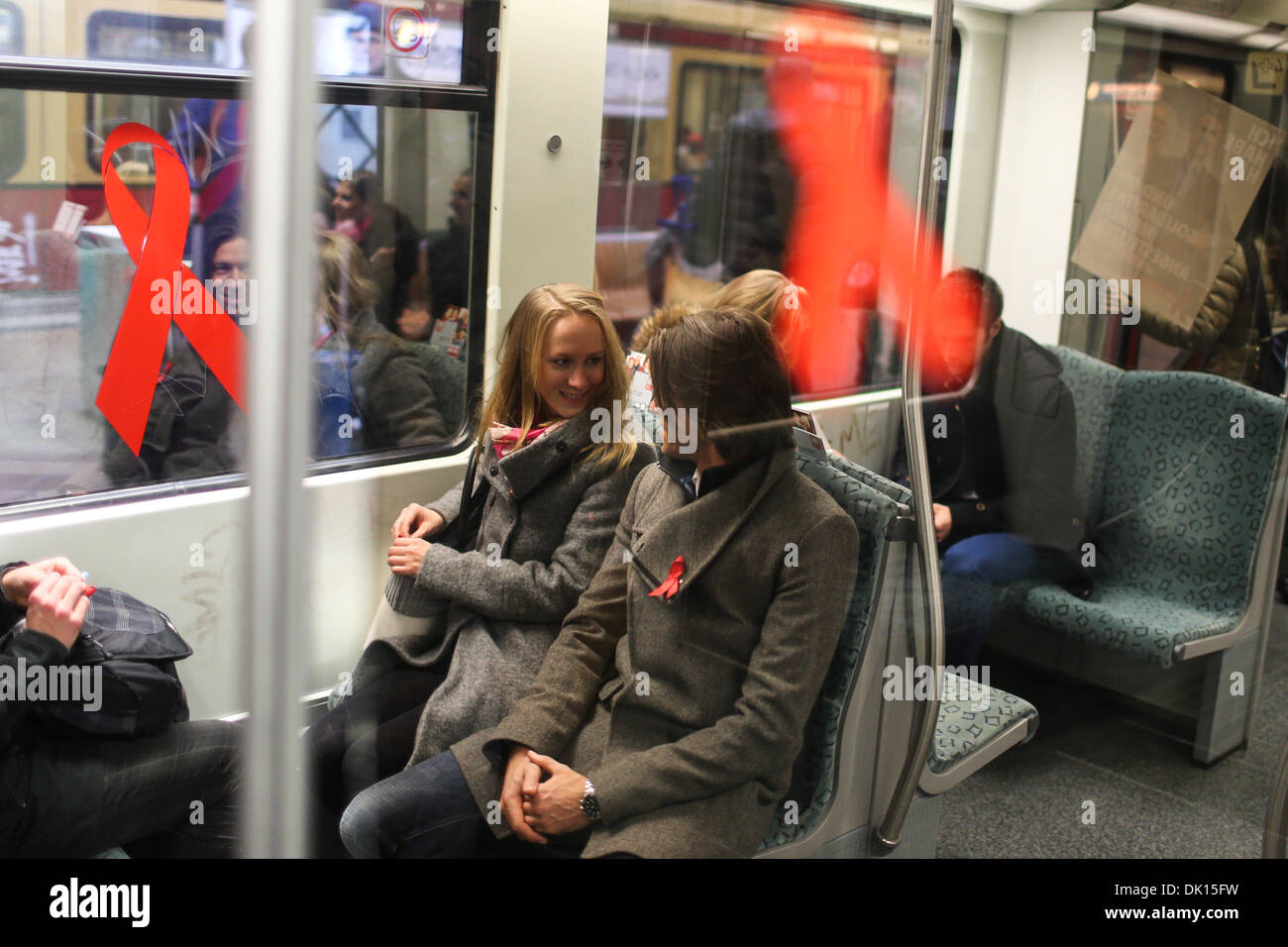 Berlin, Germany. 1st Dec, 2013. Passengers wearing red ribbons sit in a ...