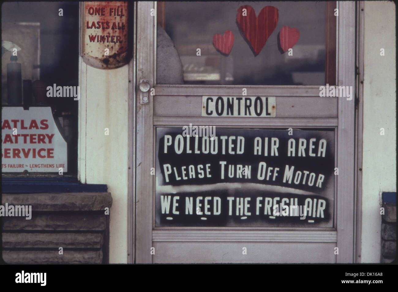 A pollution warning sign is affixed to the door of a gasoline service ...