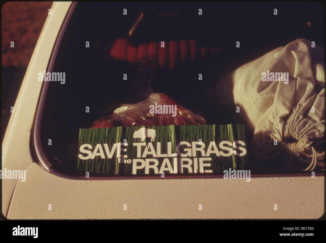 The rear window of a car displays a 'Save the Tallgrass Prairie ...