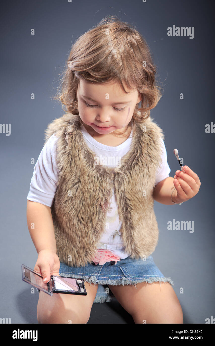 studio shot of a little girl making oneself up Stock Photo - Alamy