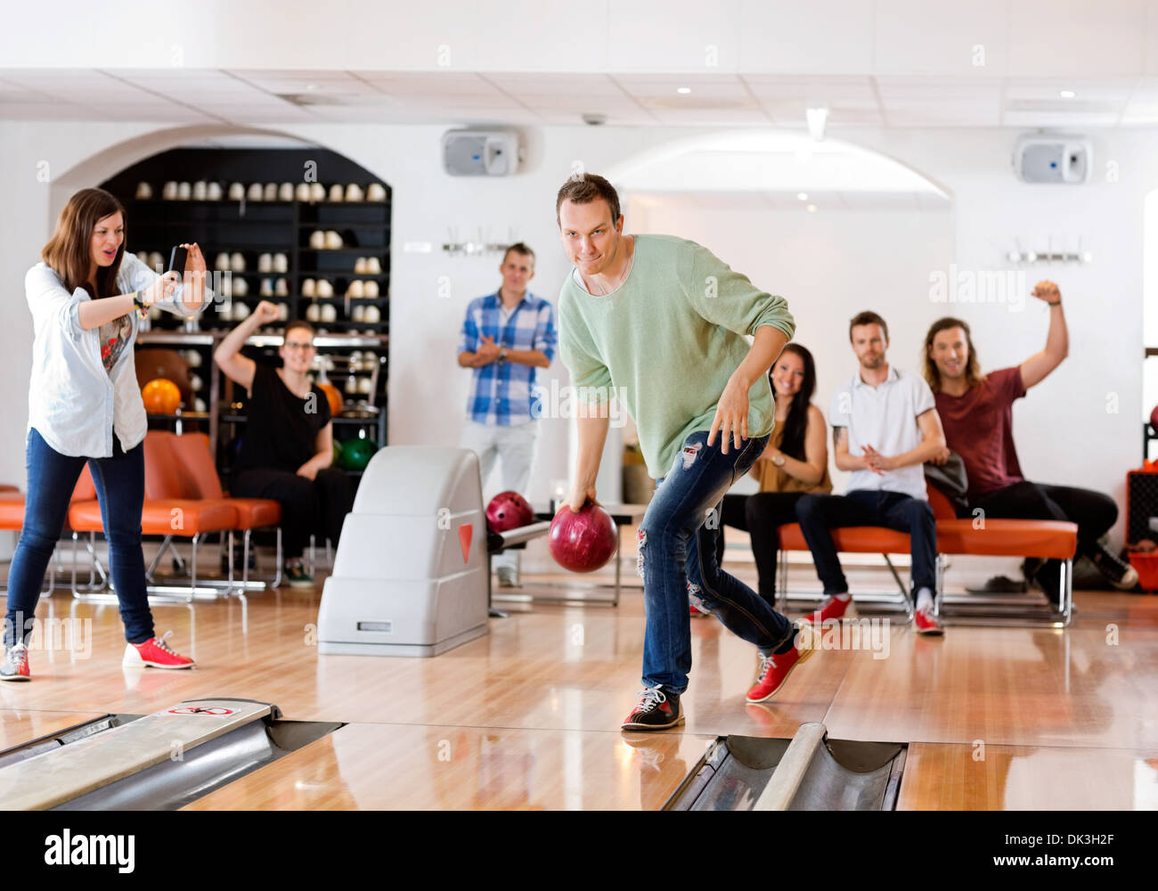 Man Bowling With Friends Cheering in Club Stock Photo - Alamy