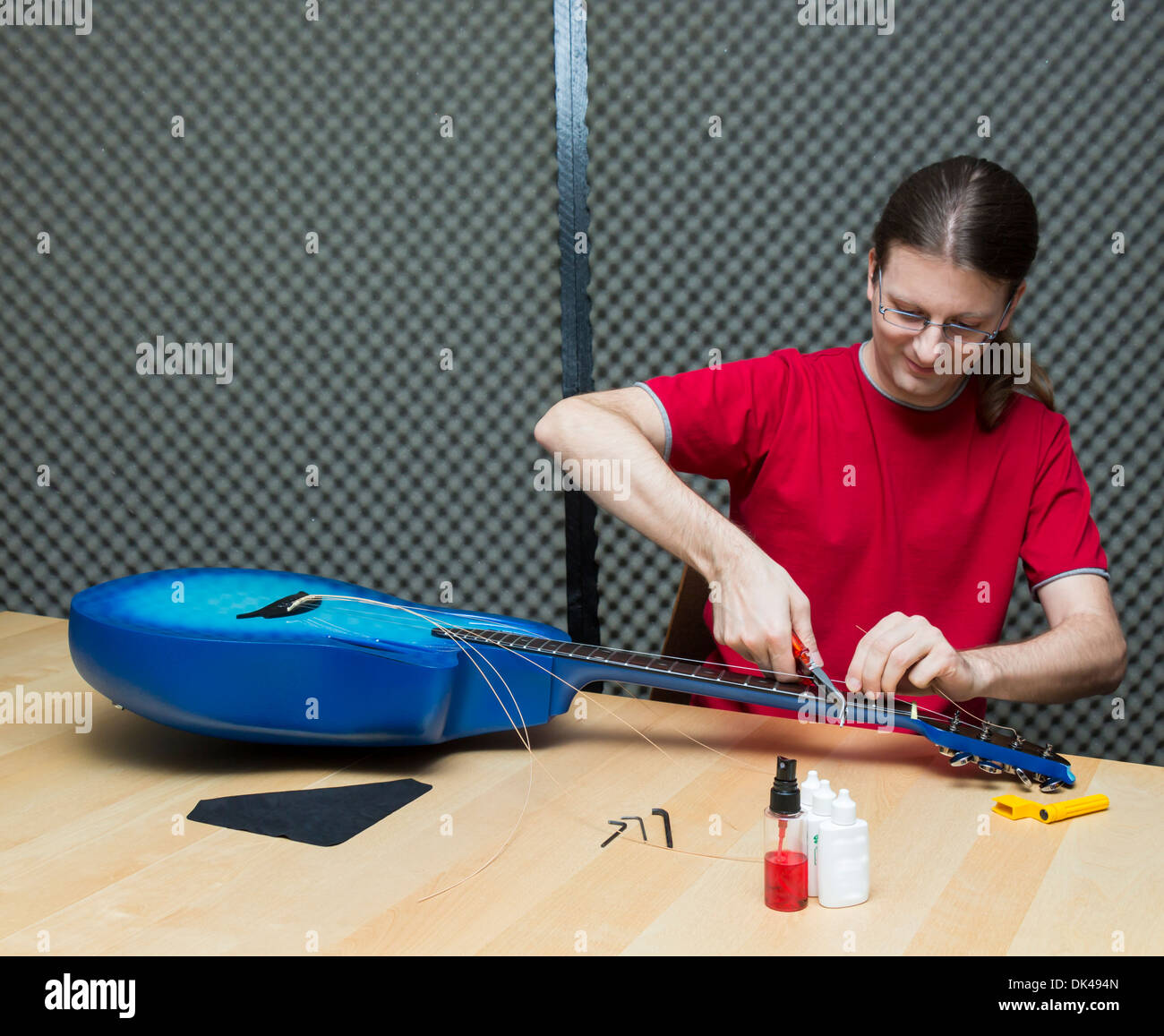 Guitar technician cutting the old strings away ( Series with the same ...