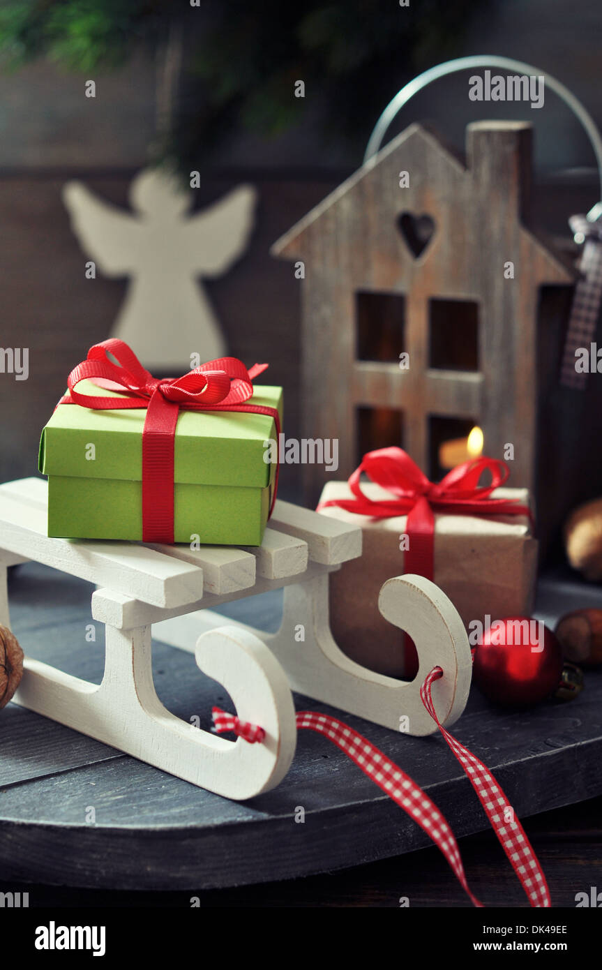Sled toy with gift boxes and lantern on wooden background Stock Photo ...