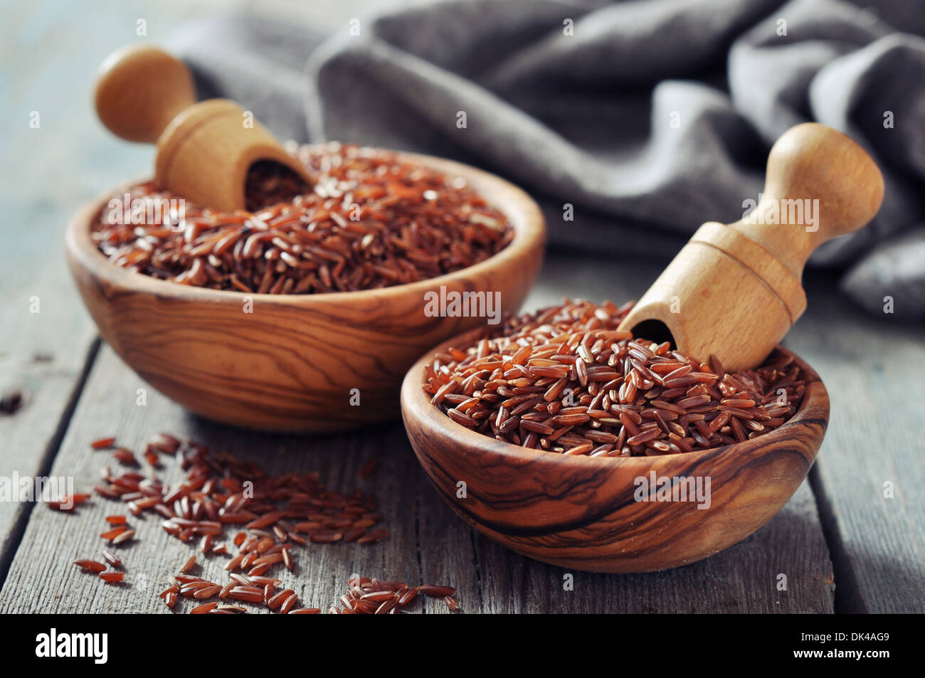 Red rice in a bowl with scoop on wooden background Stock Photo - Alamy