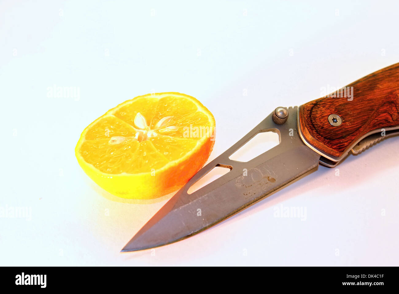 Half of lemon and sharp knife on white background Stock Photo - Alamy