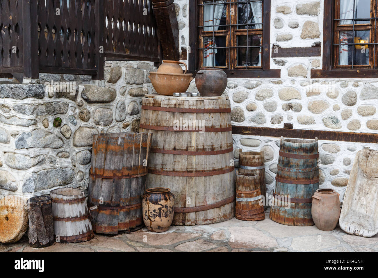 Old wooden barrels and stones as decoration of an exterior of the house ...