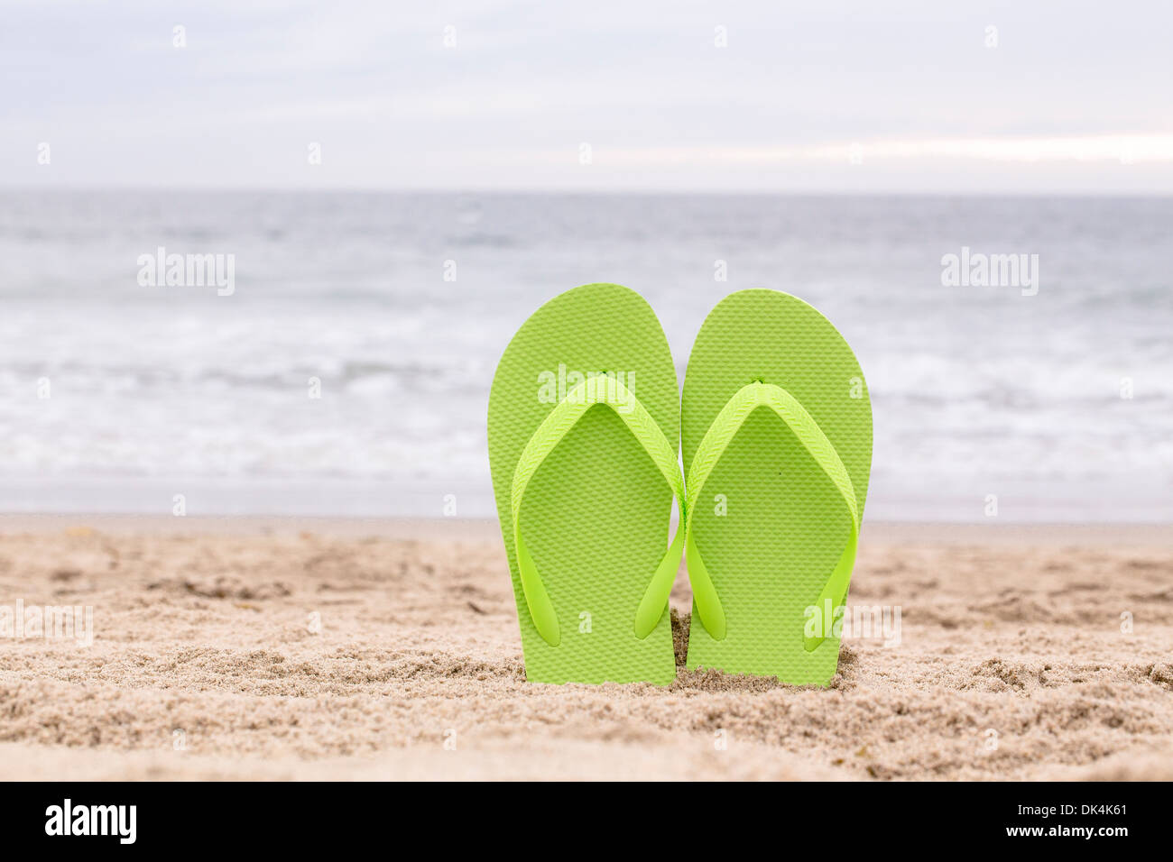 Green Sandals in the sand Stock Photo - Alamy