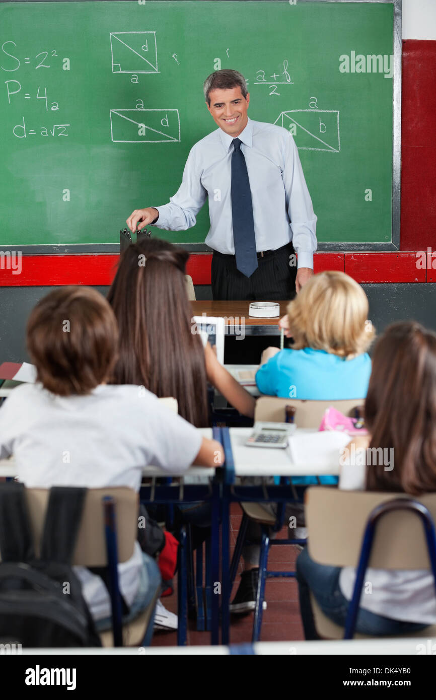 Teacher Looking At Students In Classroom Stock Photo - Alamy