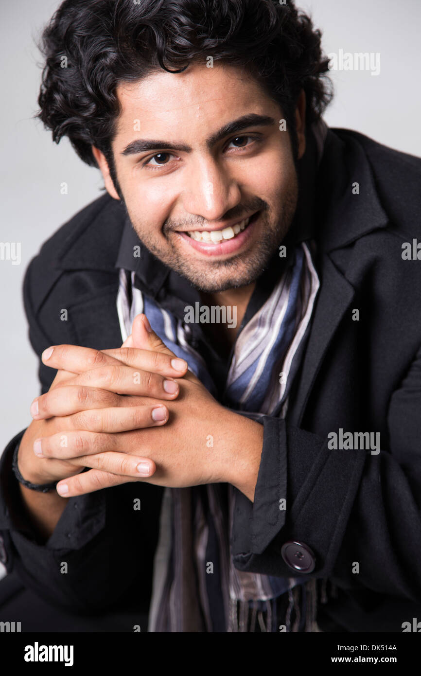 Smiling young Indian man with hands folded Stock Photo - Alamy