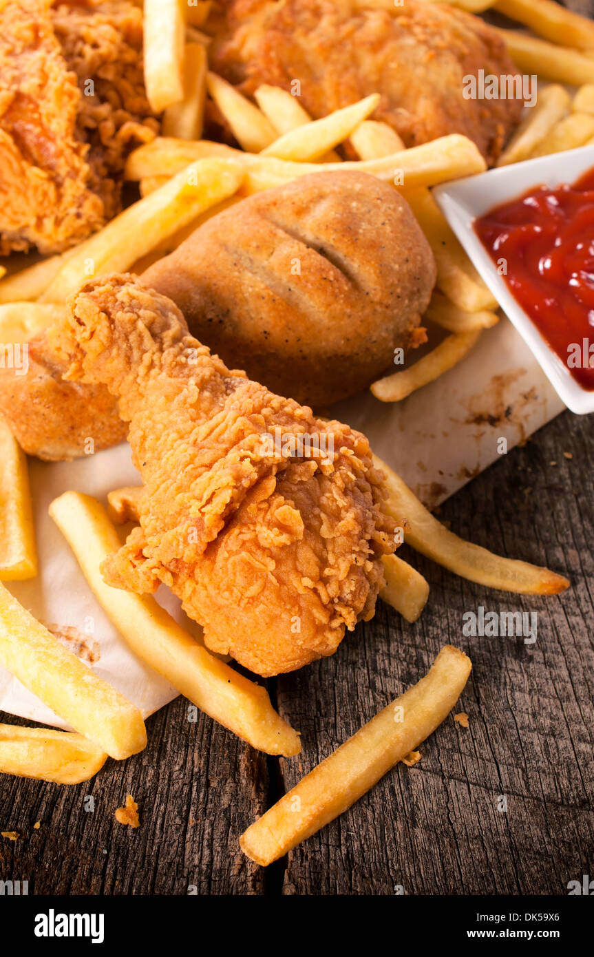 Junk food on the table.Deep fried chicken legs and french fries Stock ...