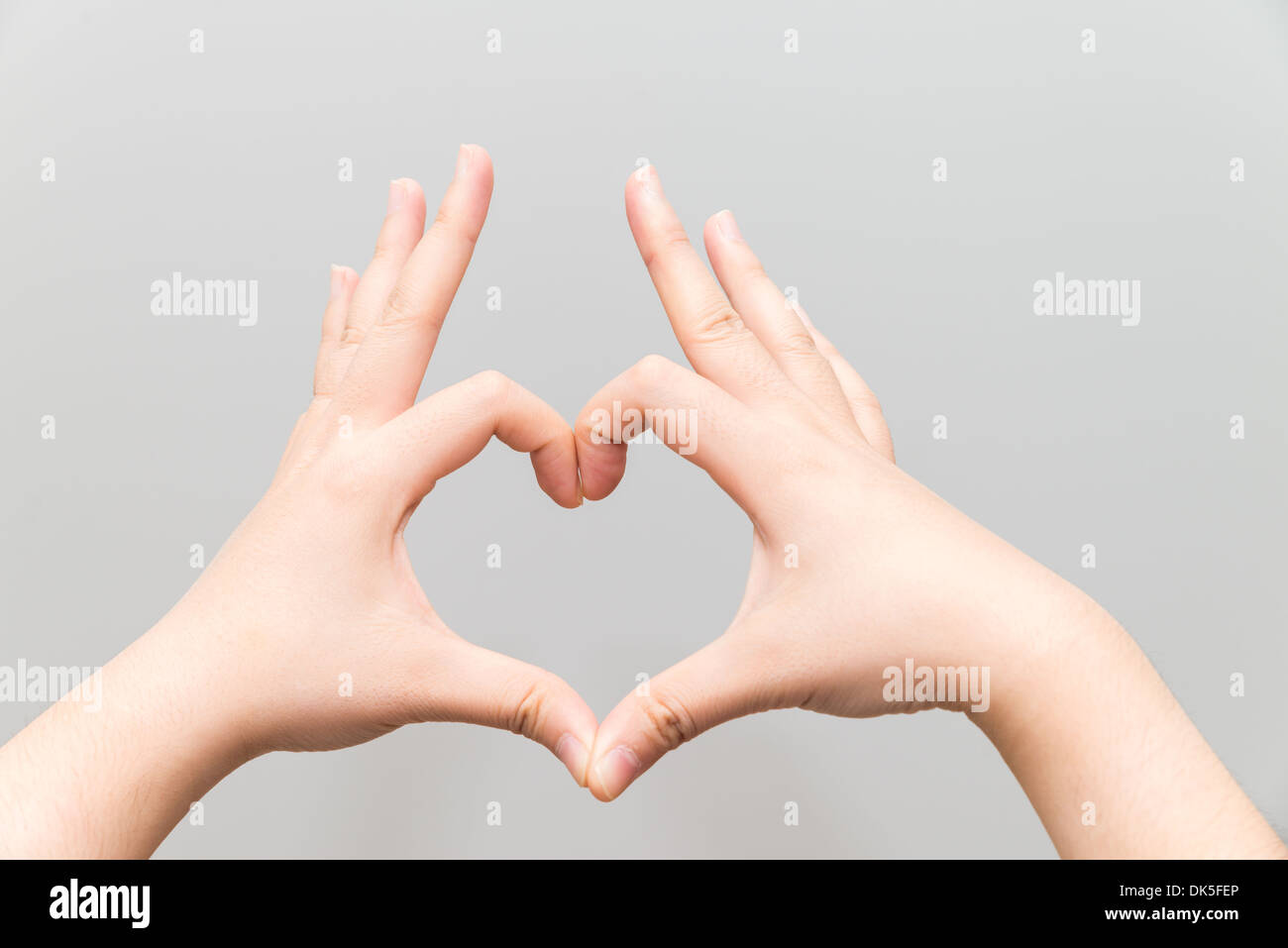 Human hands making a heart shape on light gray background Stock Photo ...