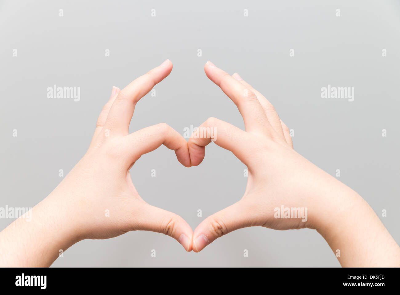 Human hands making a heart shape on light gray background Stock Photo ...