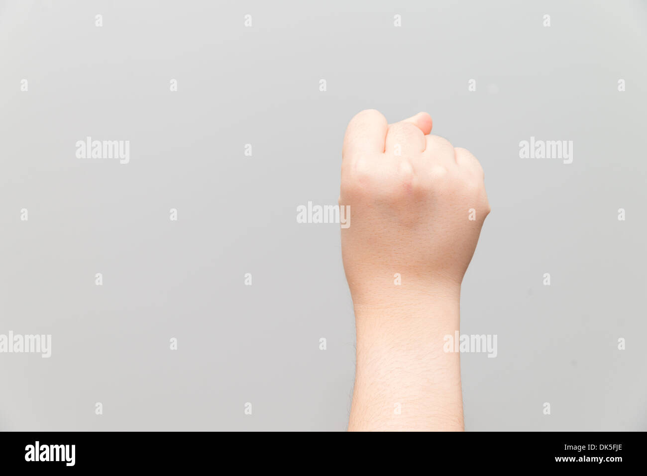 Human hand with closed fist on gray background Stock Photo - Alamy