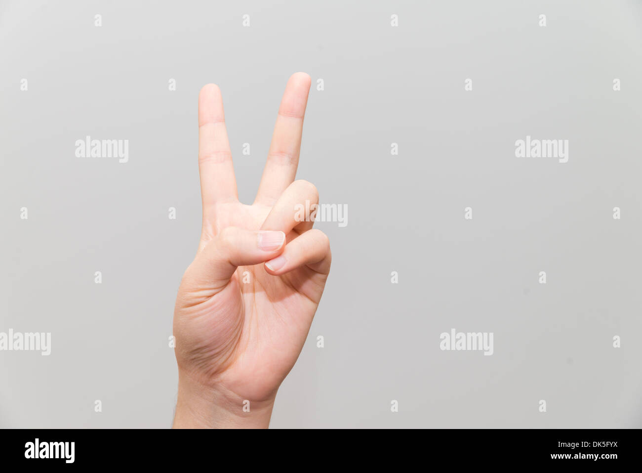 Human hand with two finger posing on light gray background Stock Photo ...