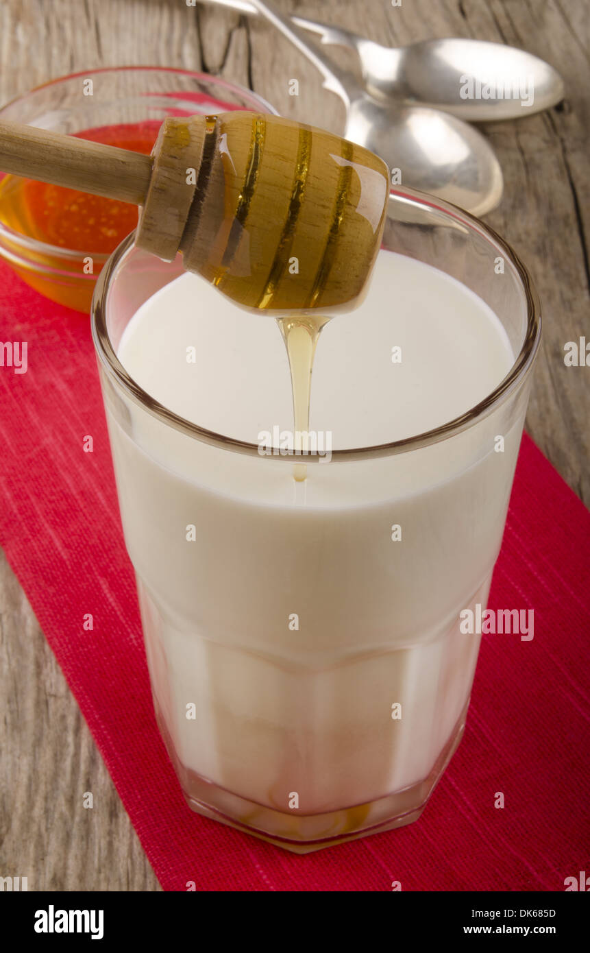 sweet honey is poured into a glass of warm milk Stock Photo - Alamy