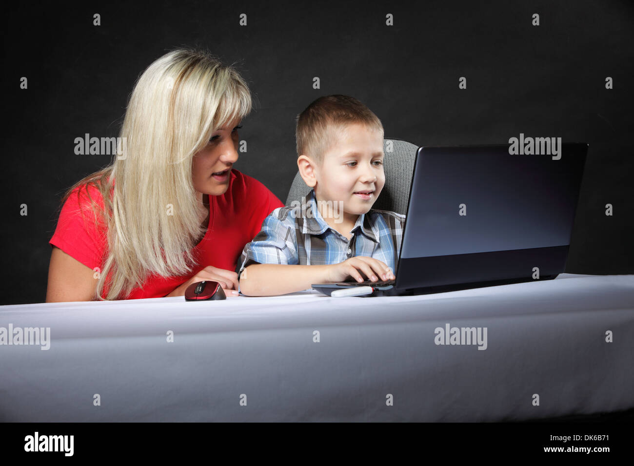 mother with son together looking on the laptop computer black ...