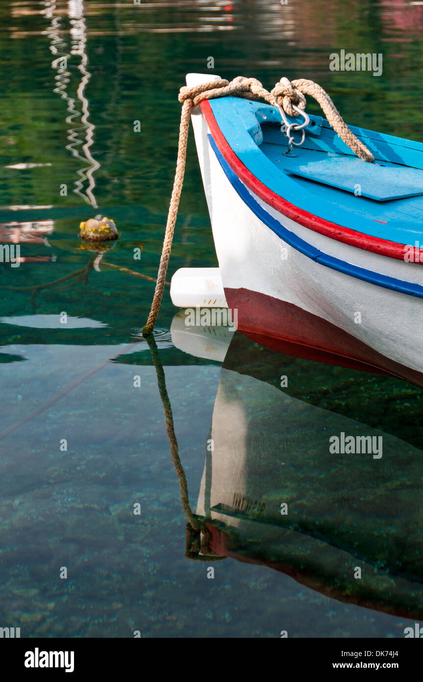 Fishing boat hull reflected in the water of Kioni harbour Stock Photo ...