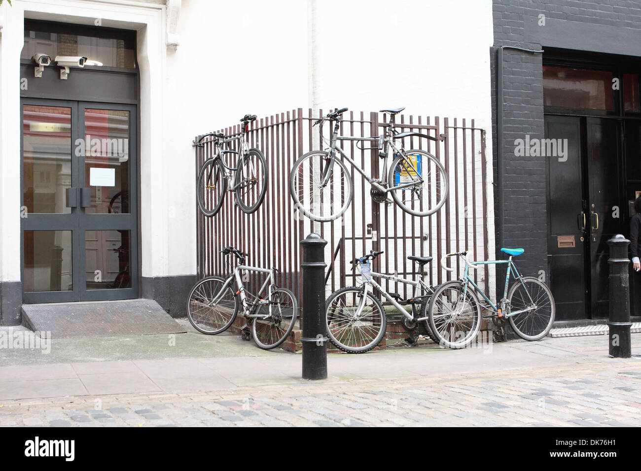 Cycles secured to railings in a London street Stock Photo - Alamy