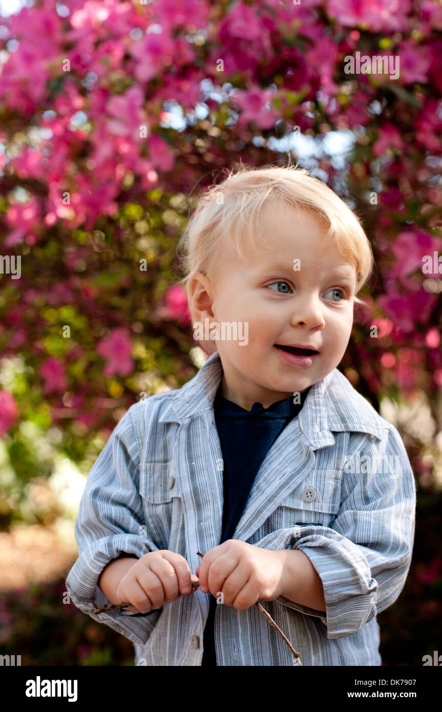 A boy smiles in front of a flowering Spring shrub Stock Photo - Alamy