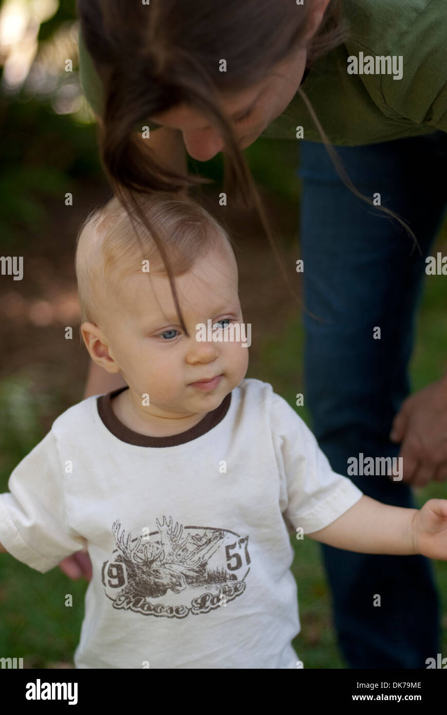 A mother helps a baby boy to stand Stock Photo - Alamy