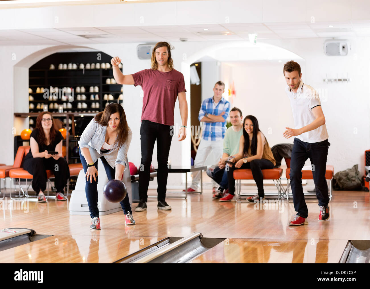 Man And Woman Bowling With Friends in Background Stock Photo - Alamy