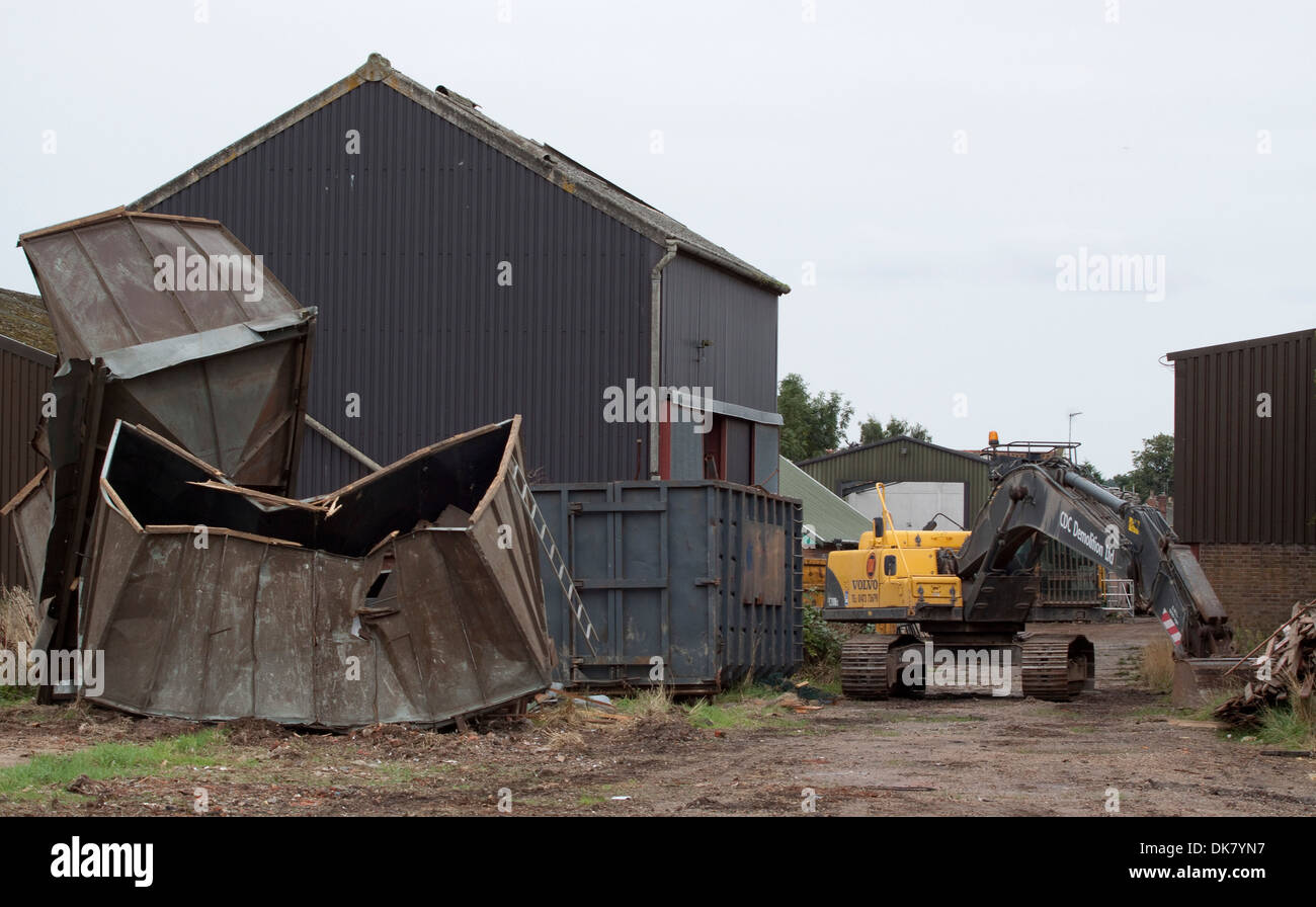 Enormous metal grain storage bins crumpled by a digger Stock Photo - Alamy