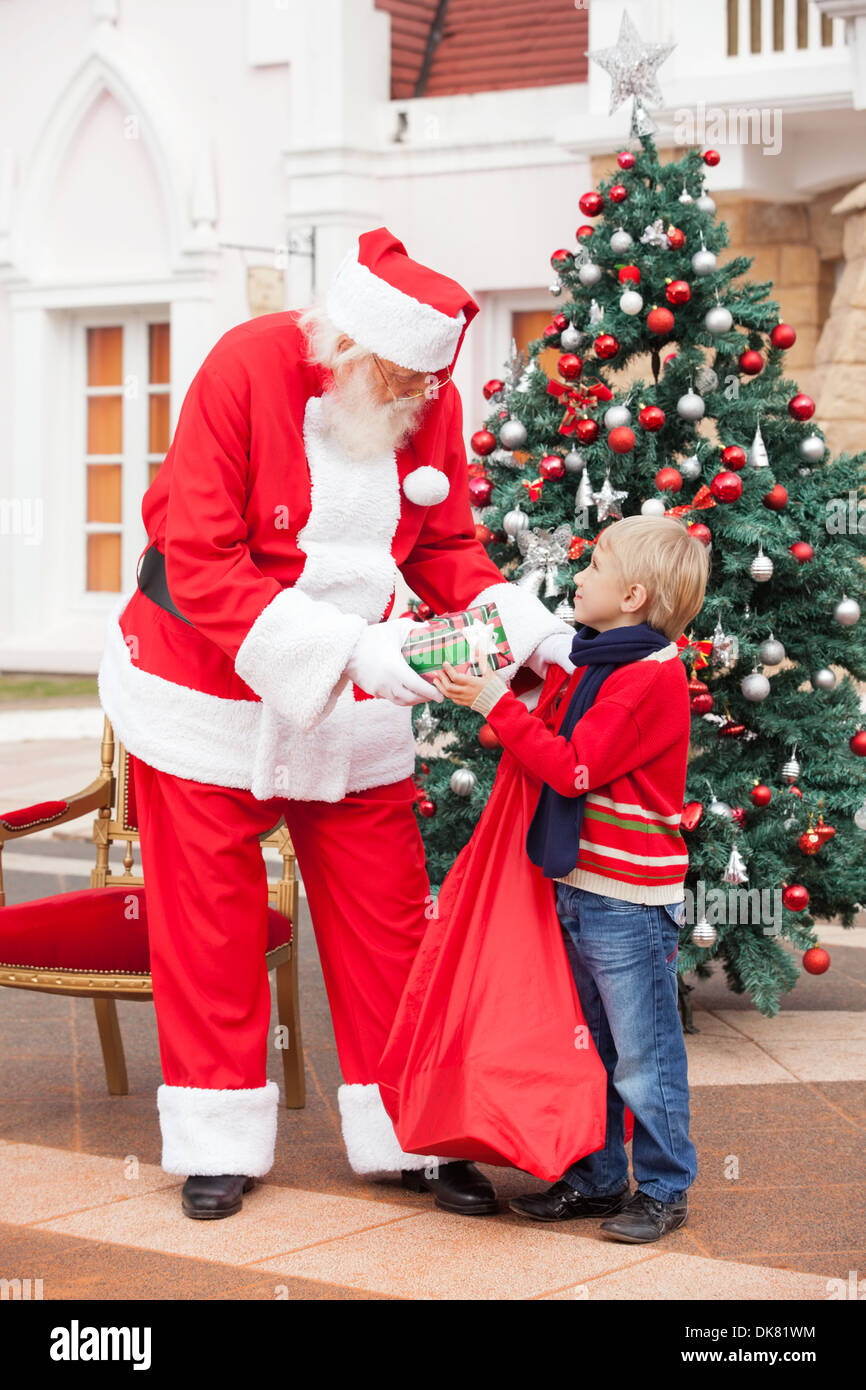 Santa Claus Giving Present To Boy Stock Photo - Alamy