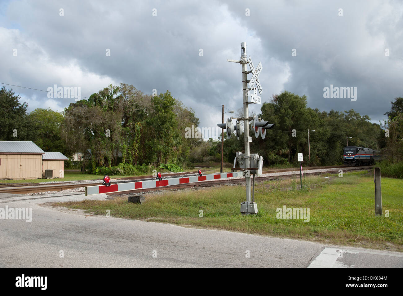 Level crossing barrier in the closed position with train approaching ...