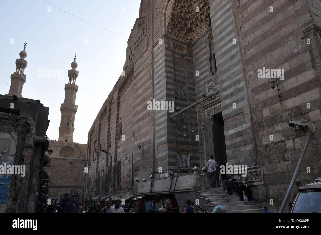 A marketplace on a street next to the facade of a huge mosque in the ...