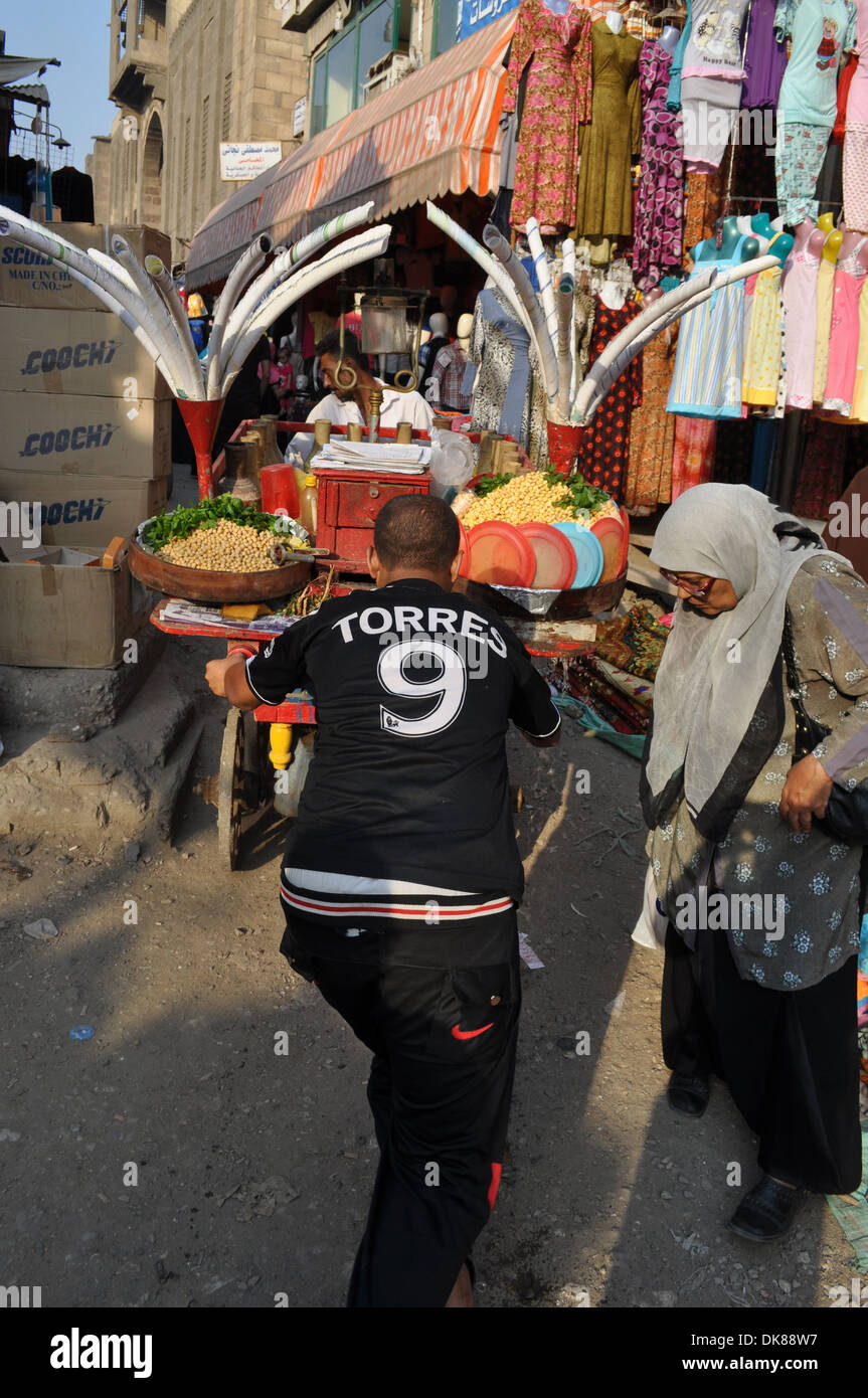 Young local men push and pull a food cart through a market in the ...