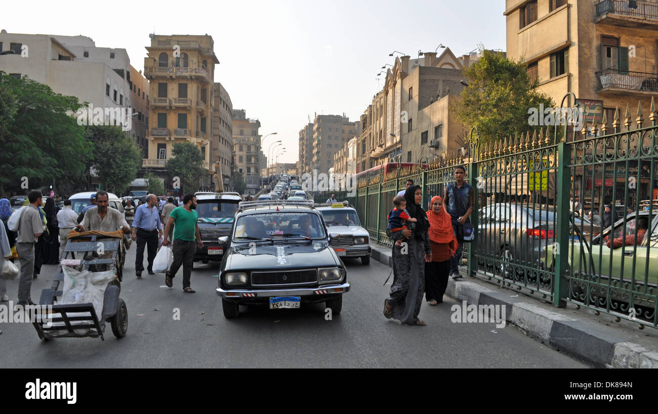 People walk through traffic as they cross a busy street in the Islamic ...