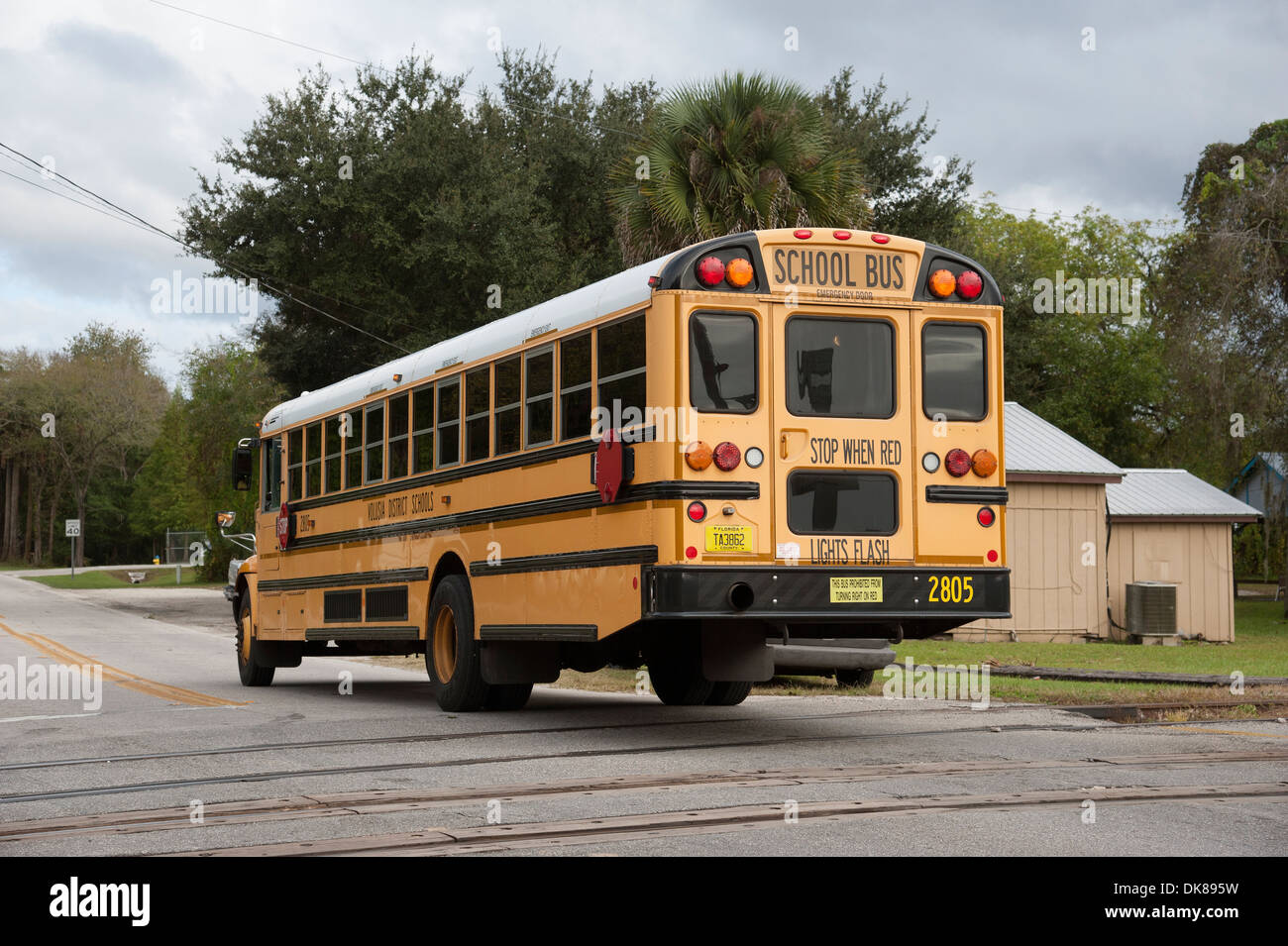 American school bus passing over railroad tracks at DeLand Florida USA ...