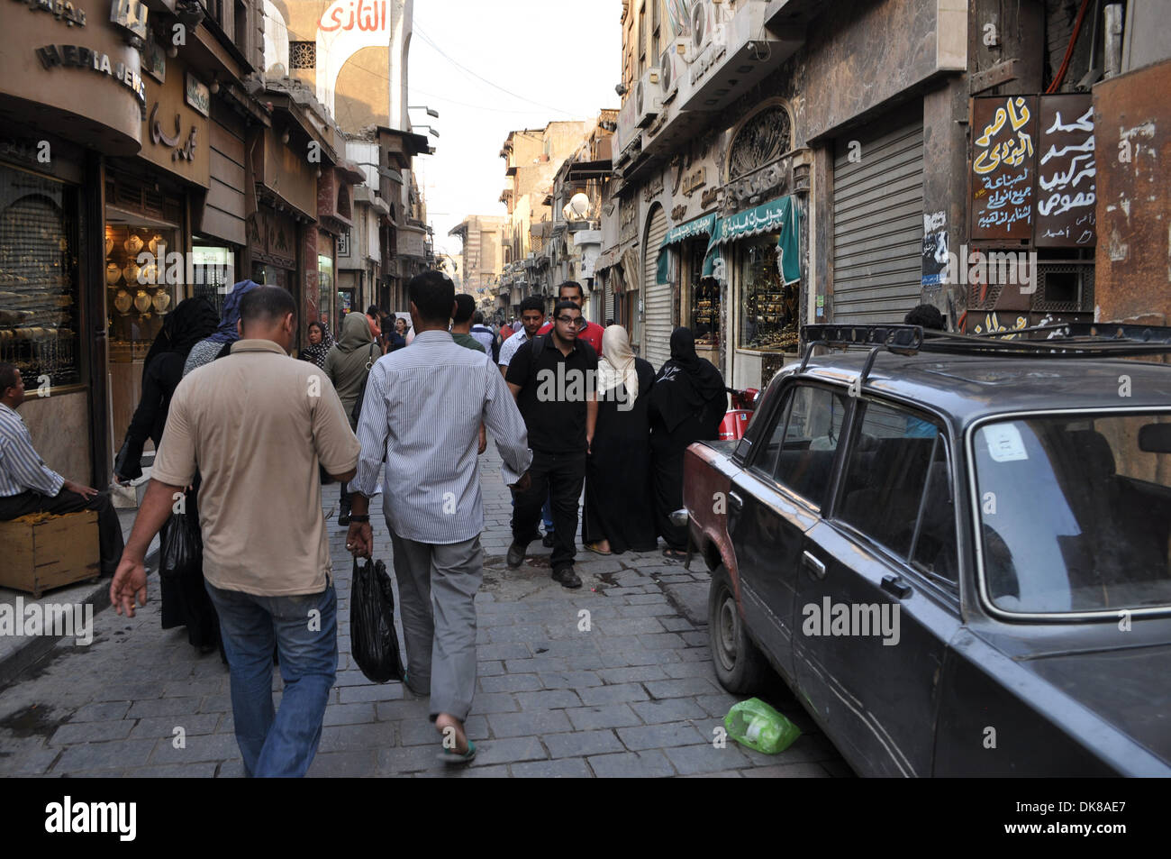 Local people walking down a narrow street in the historic Islamic ...