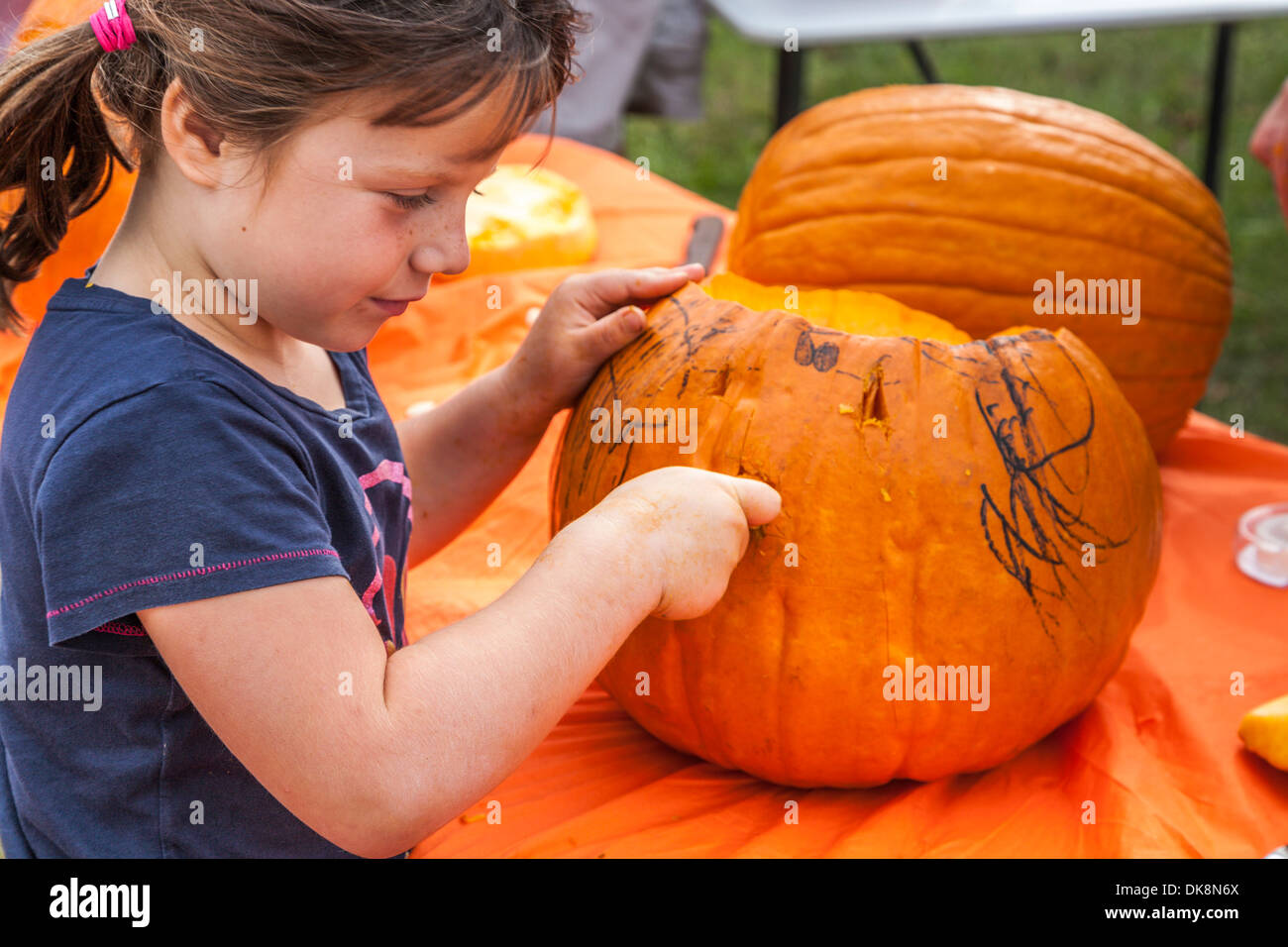 Young girl carving a pumpkin face for Halloween Stock Photo - Alamy