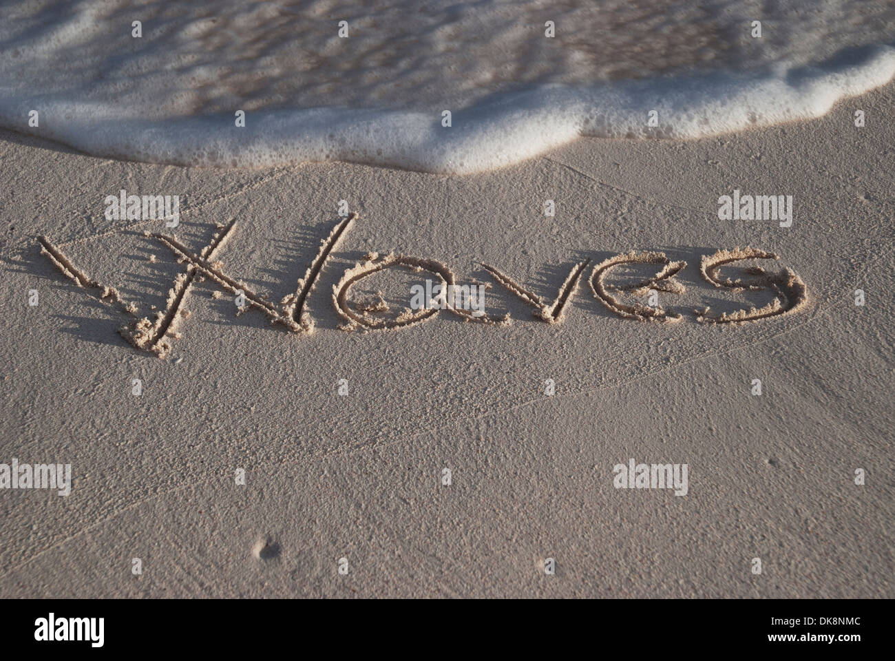 The word waves handwritten in the sand at the water's edge; Tulum ...