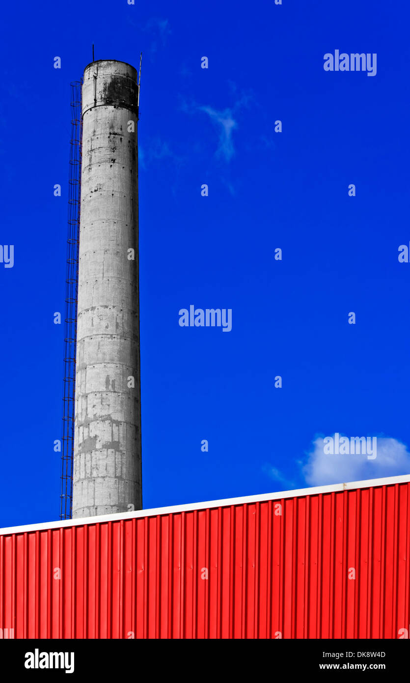 Red factory with a chimney against a blue sky Stock Photo - Alamy