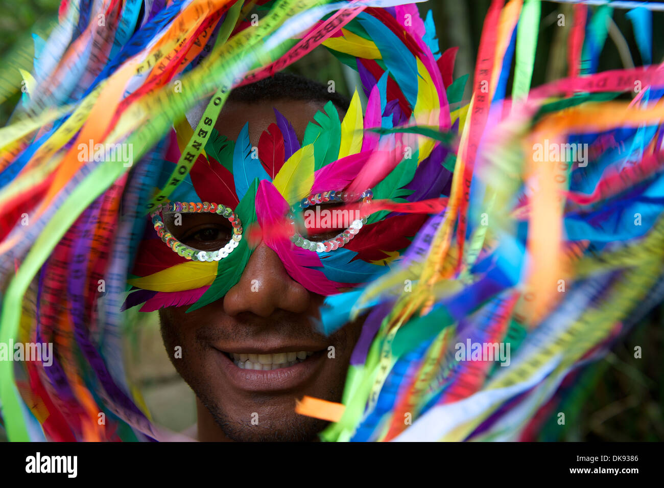 Rio Carnival scene features smiling Brazilian man in colorful mask with ...